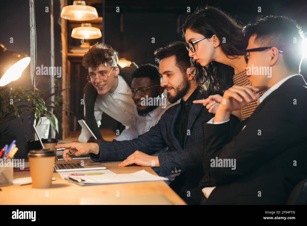 Colleagues working together in modern office using devices and gadgets ...