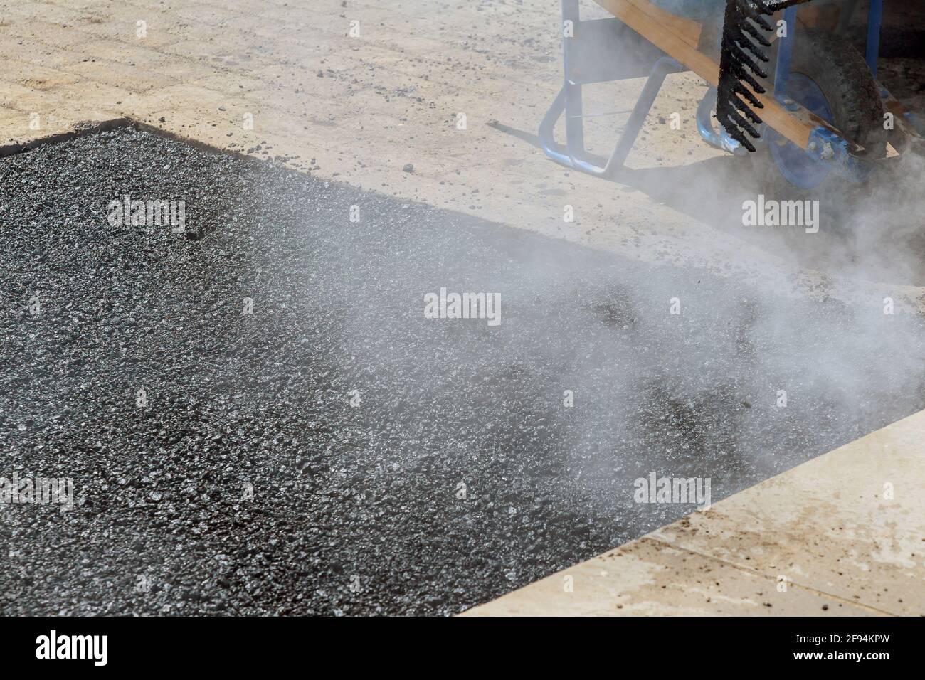While laying asphalt road worker repair asphalt covering new road ...