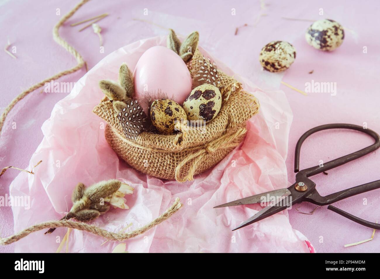 Scene of handmade Easter decoration: jute fabric, pink Easter egg ...