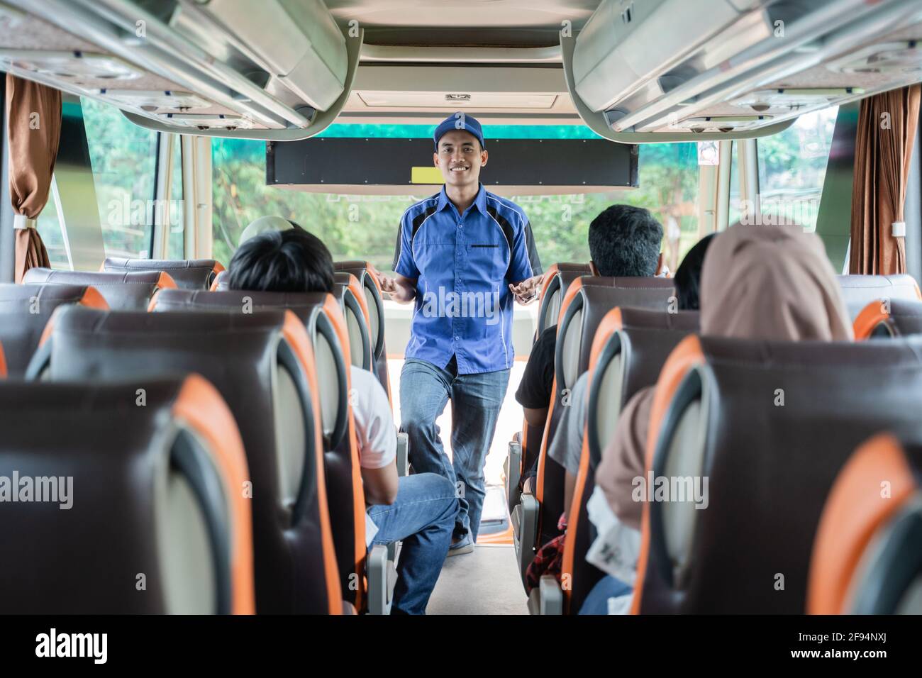 A bus crew in uniform and a hat briefs the passengers Stock Photo - Alamy