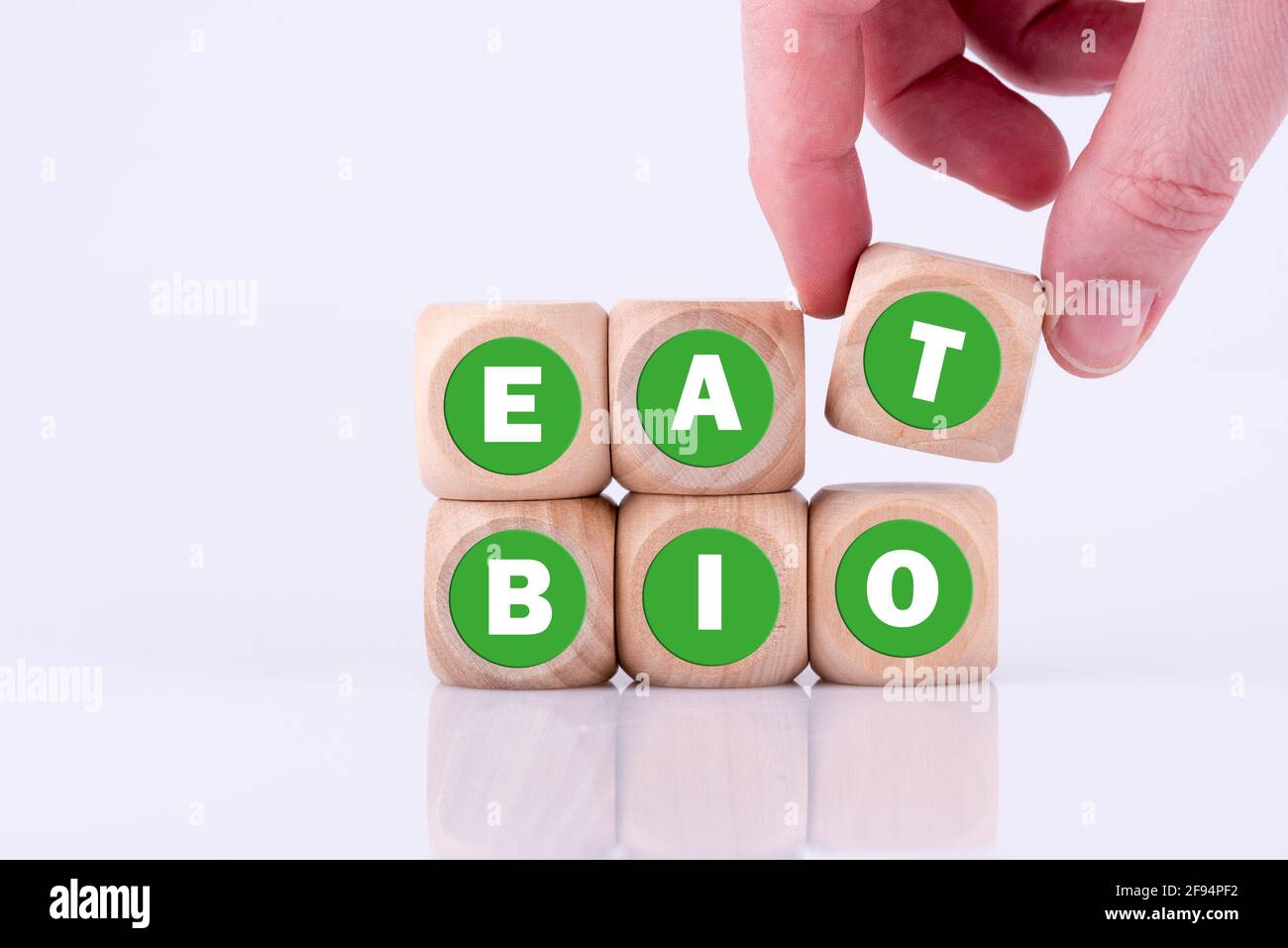 EAT BIO formed with dice letters, hand putting on the last letter Stock ...