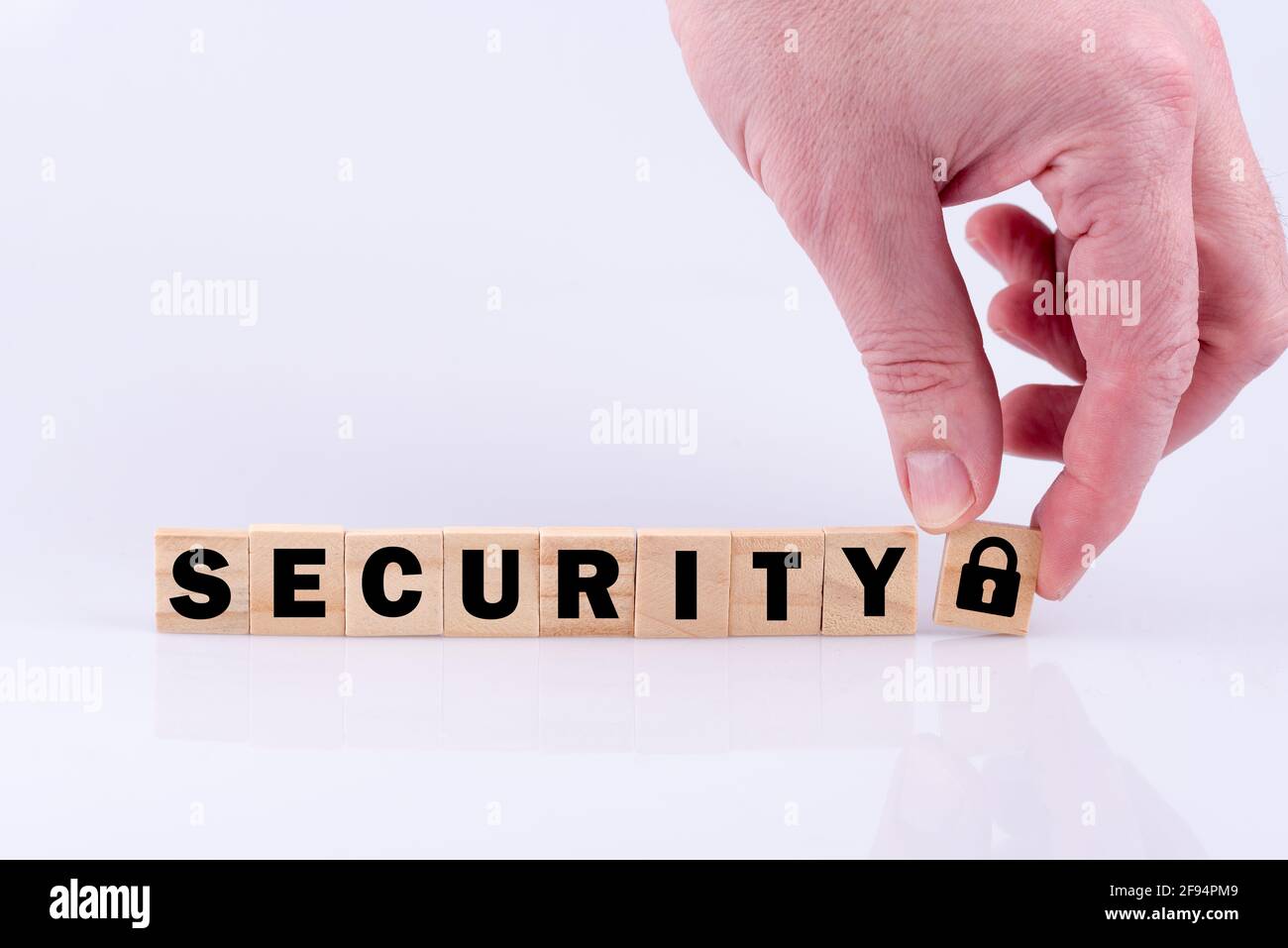 Word Security spelled from single dice letters, hand putting lock icon ...