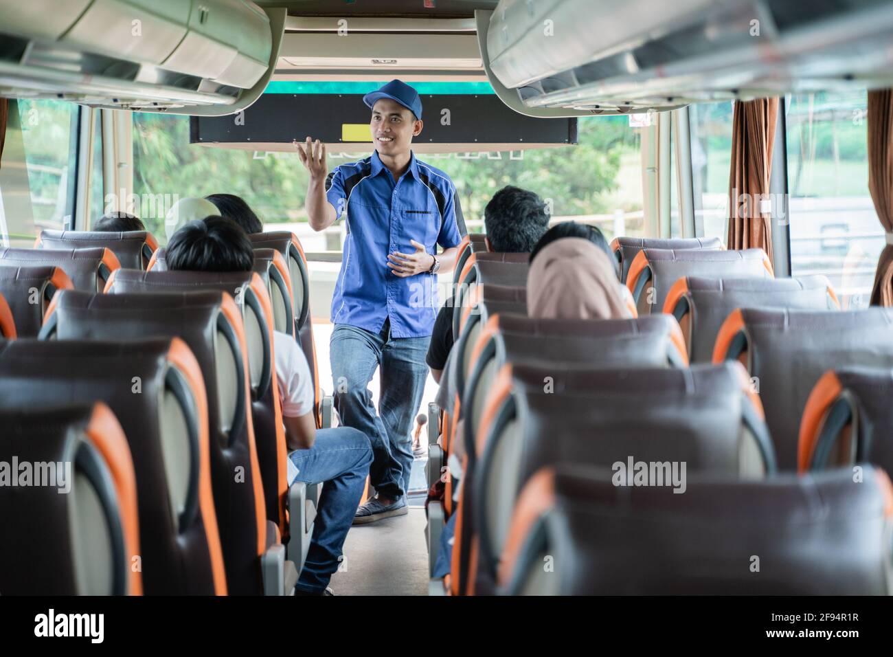 A bus crew in uniform and a hat briefs the passengers Stock Photo - Alamy