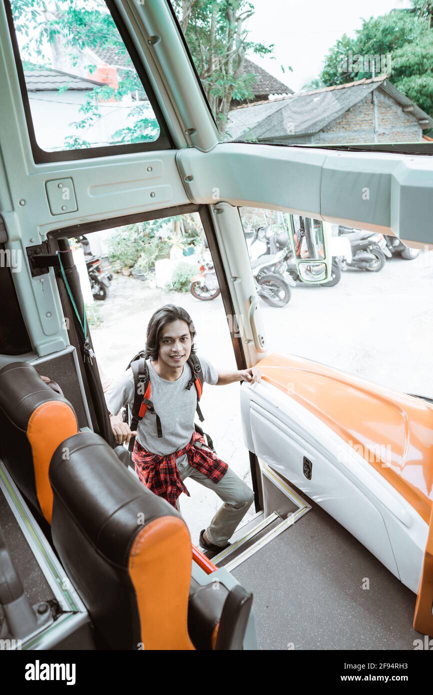 a man wearing a backpack through the bus door Stock Photo - Alamy