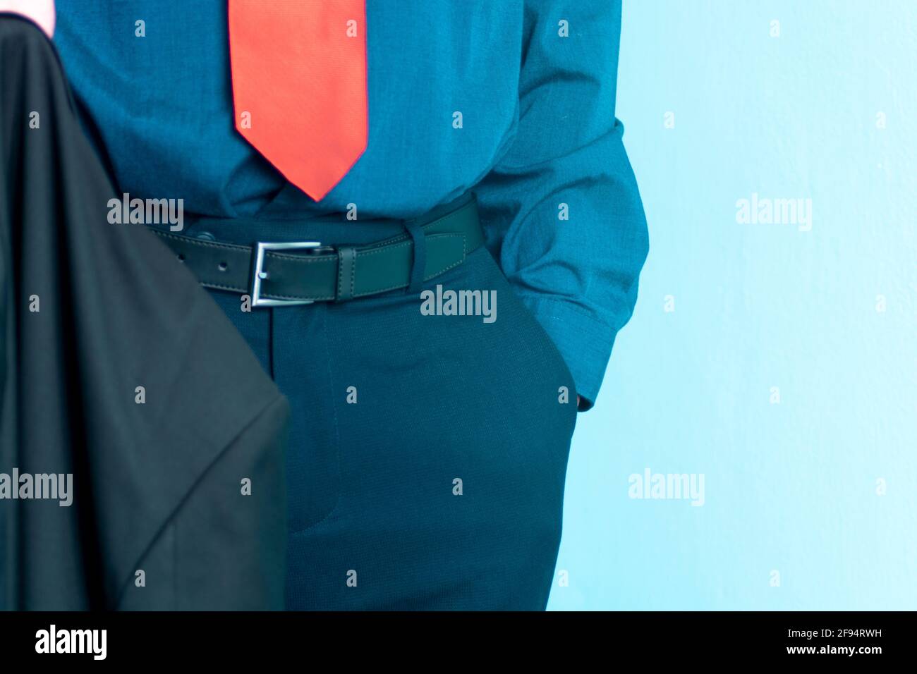 A business man standing and holding his coat with one hand in his ...