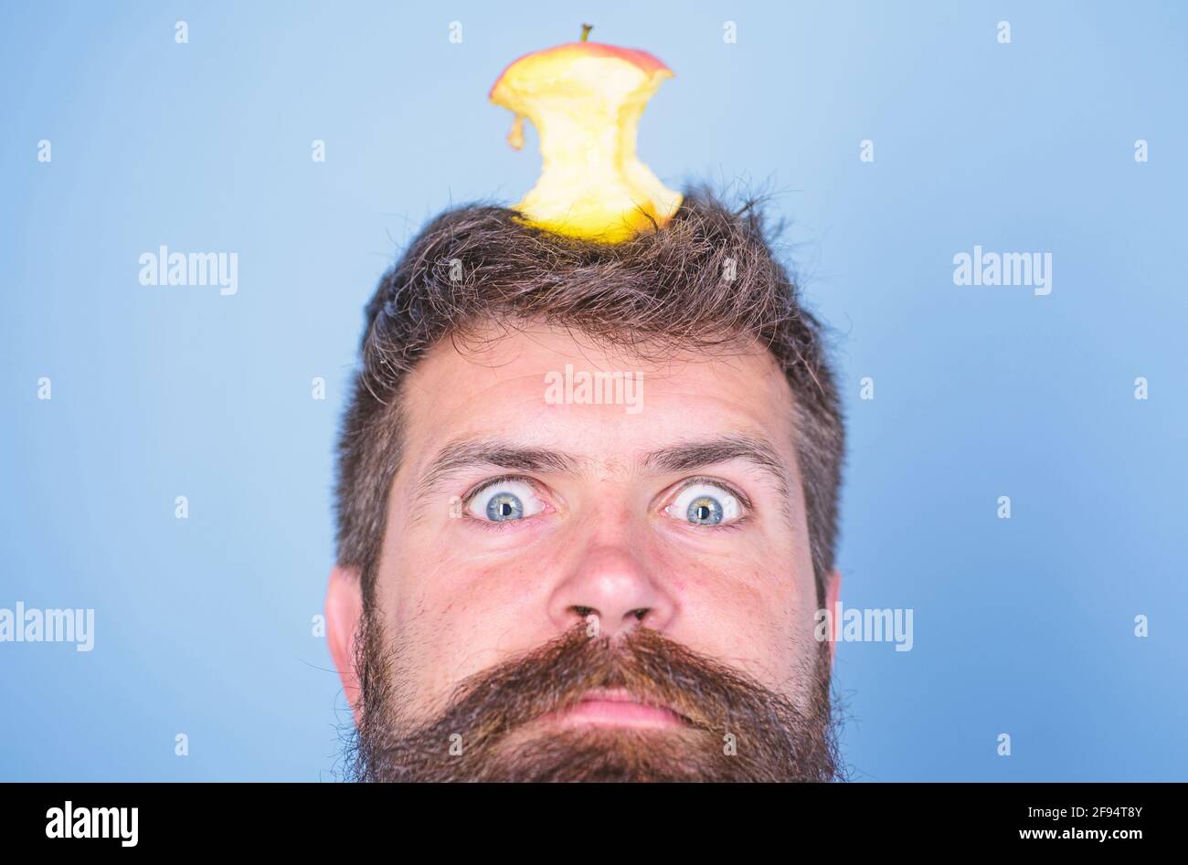 Hipster shocked face with apple stump target on head blue background ...