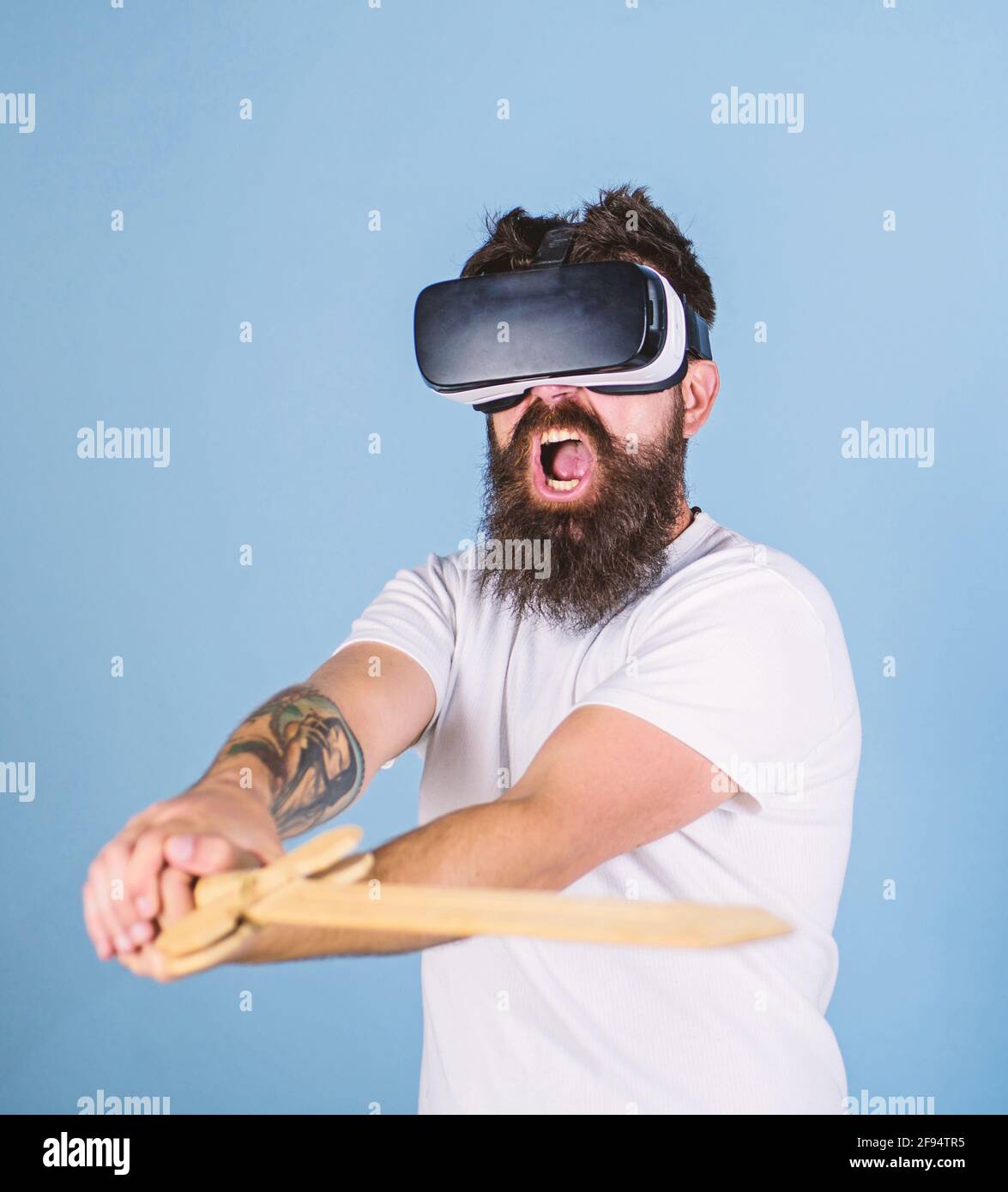 VR gamer concept. Man with beard in VR glasses, light blue background ...