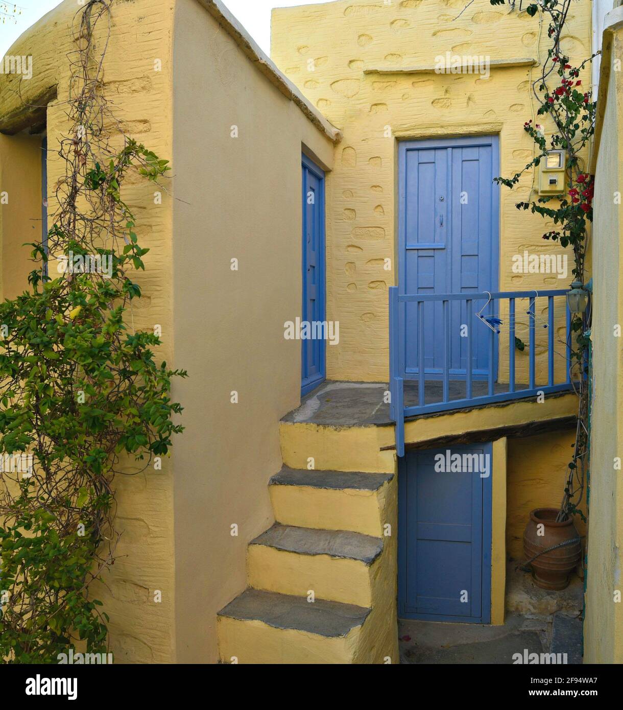 Adobe house exterior with an ochre wall and light blue wooden door and ...