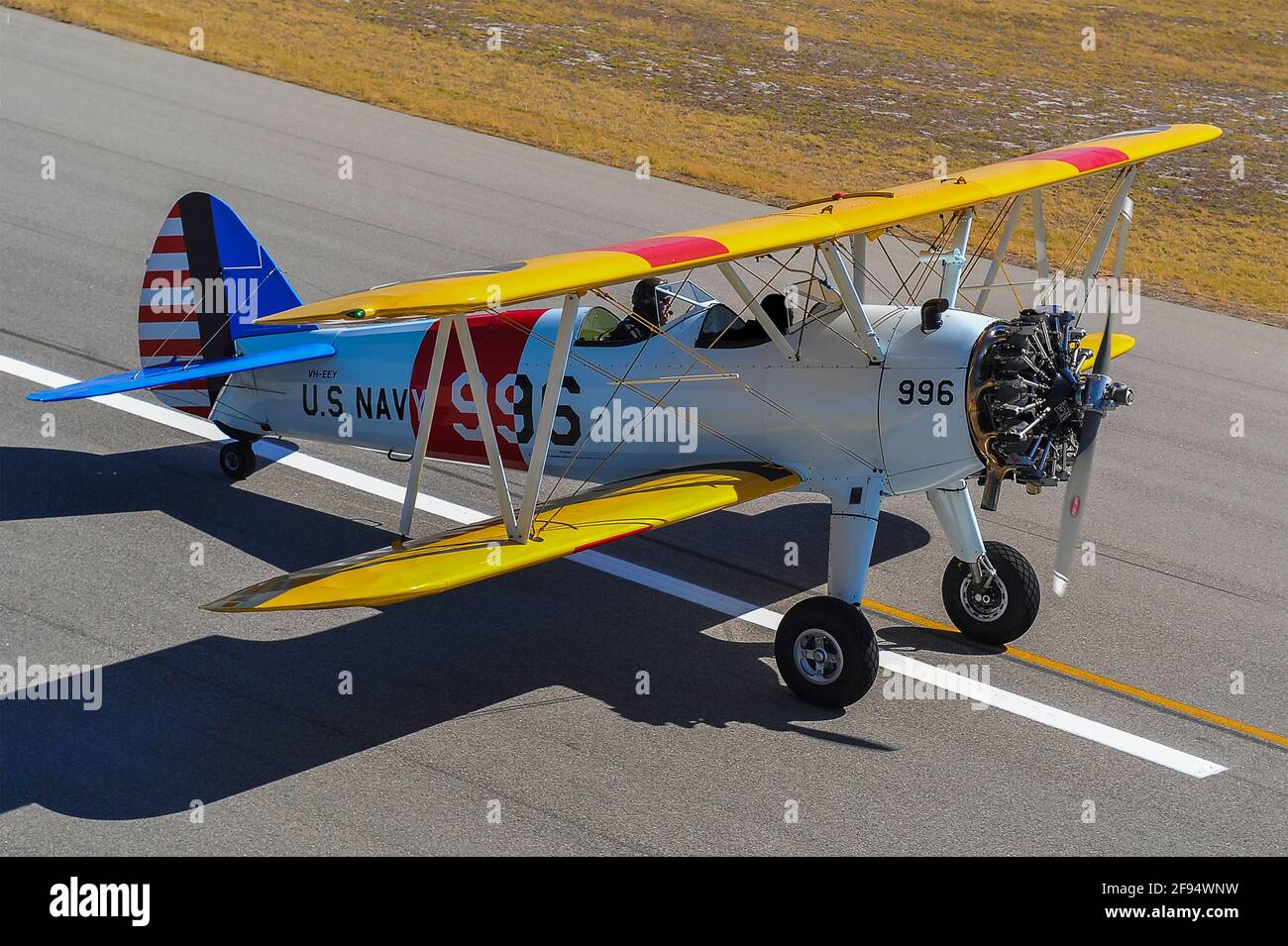 A restored 1930's Boeing Stearman biplane in US Navy colours taking off ...
