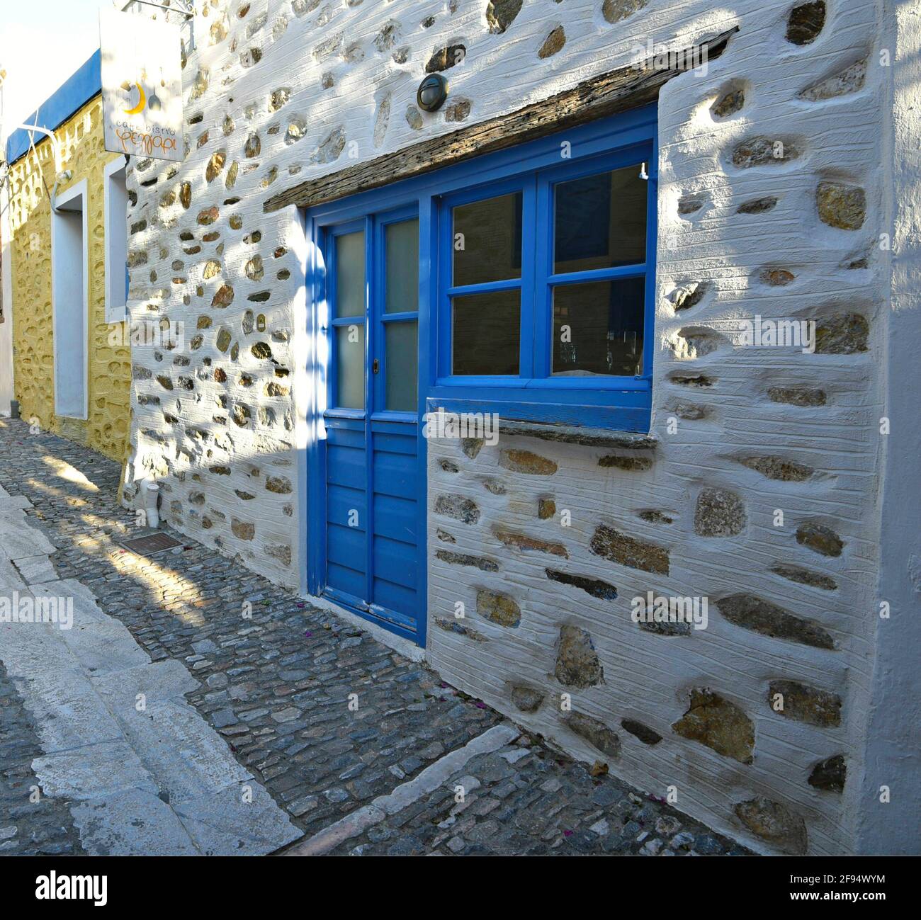 Typical Cycladic architecture facade with a whitewashed stone wall and ...