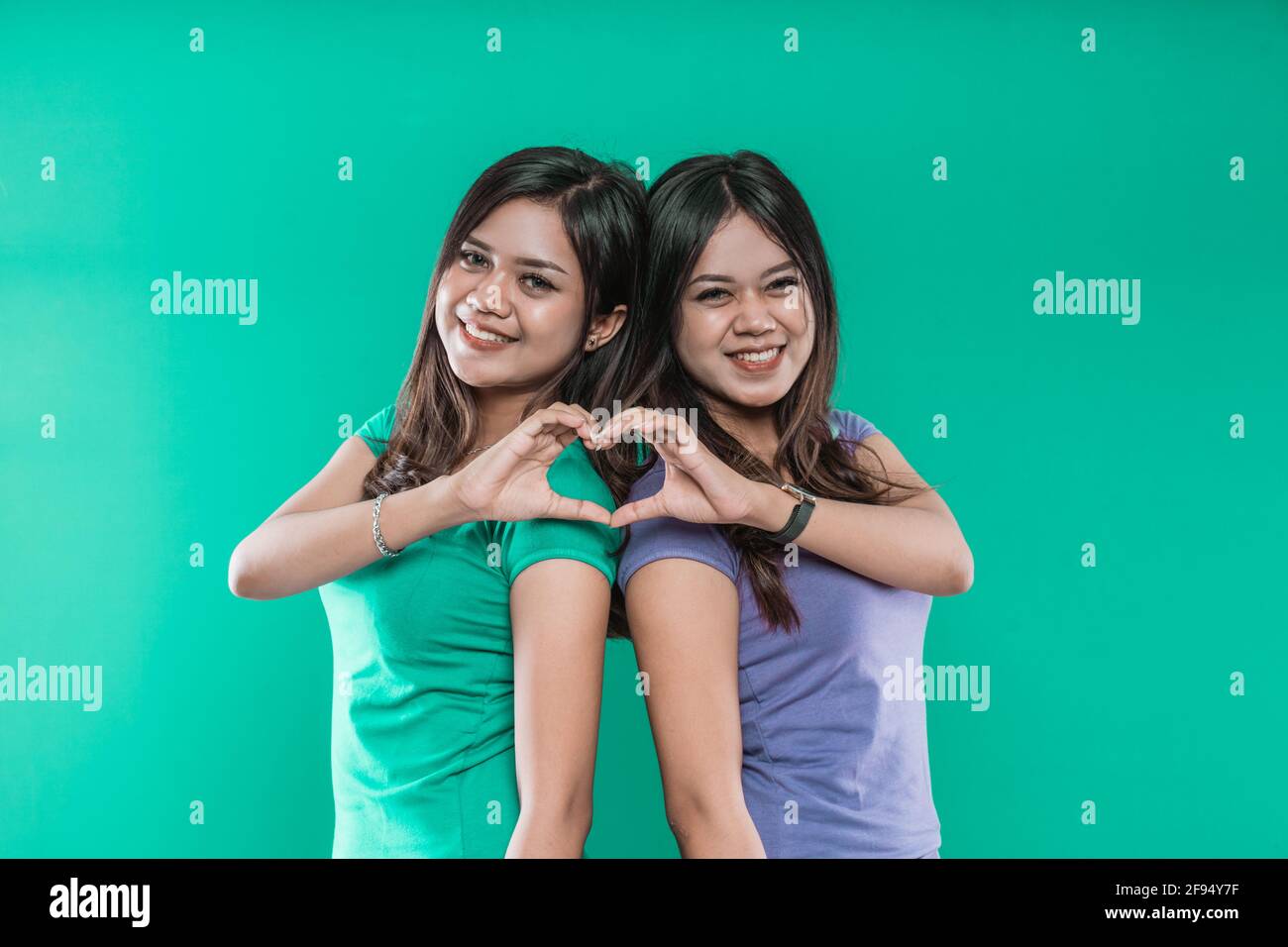 Beautiful twin sisters show a heart from their hands Stock Photo - Alamy