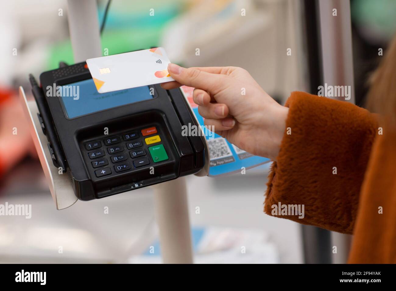 Woman hand with credit bank card pays for purchases at the checkout ...
