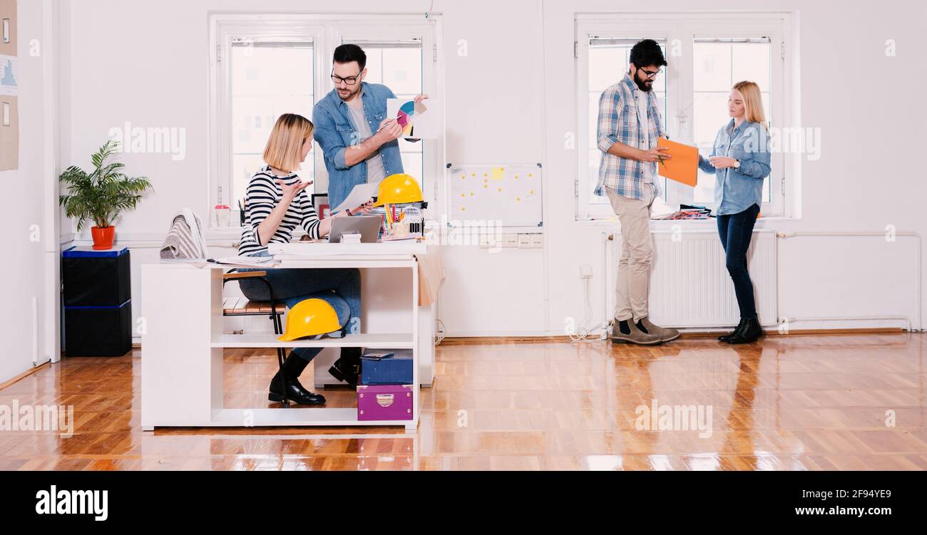Team of young modern hardworking designers working together in the ...