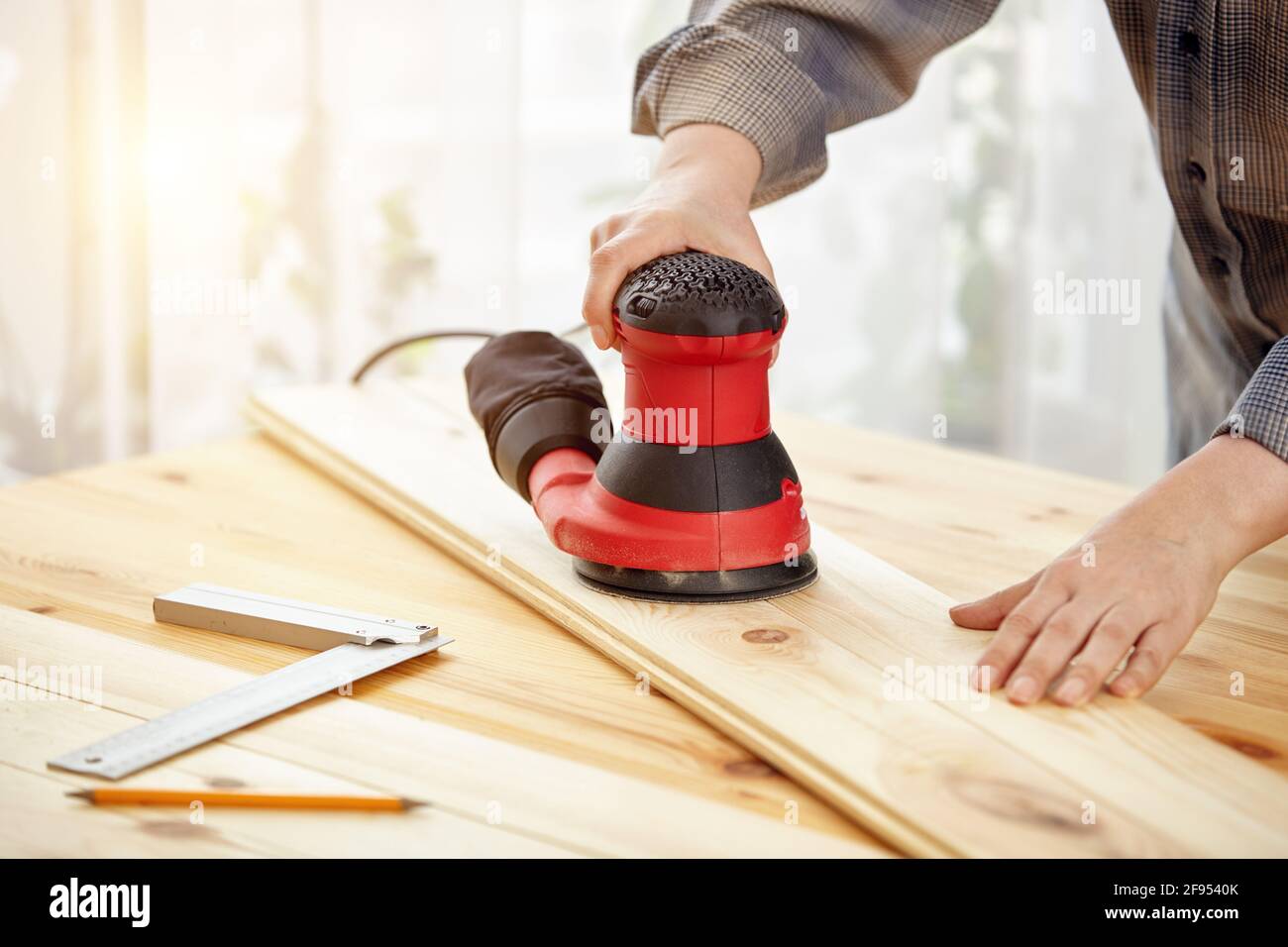 Carpenter works with wood in the workshop. A woman works in a carpentry ...