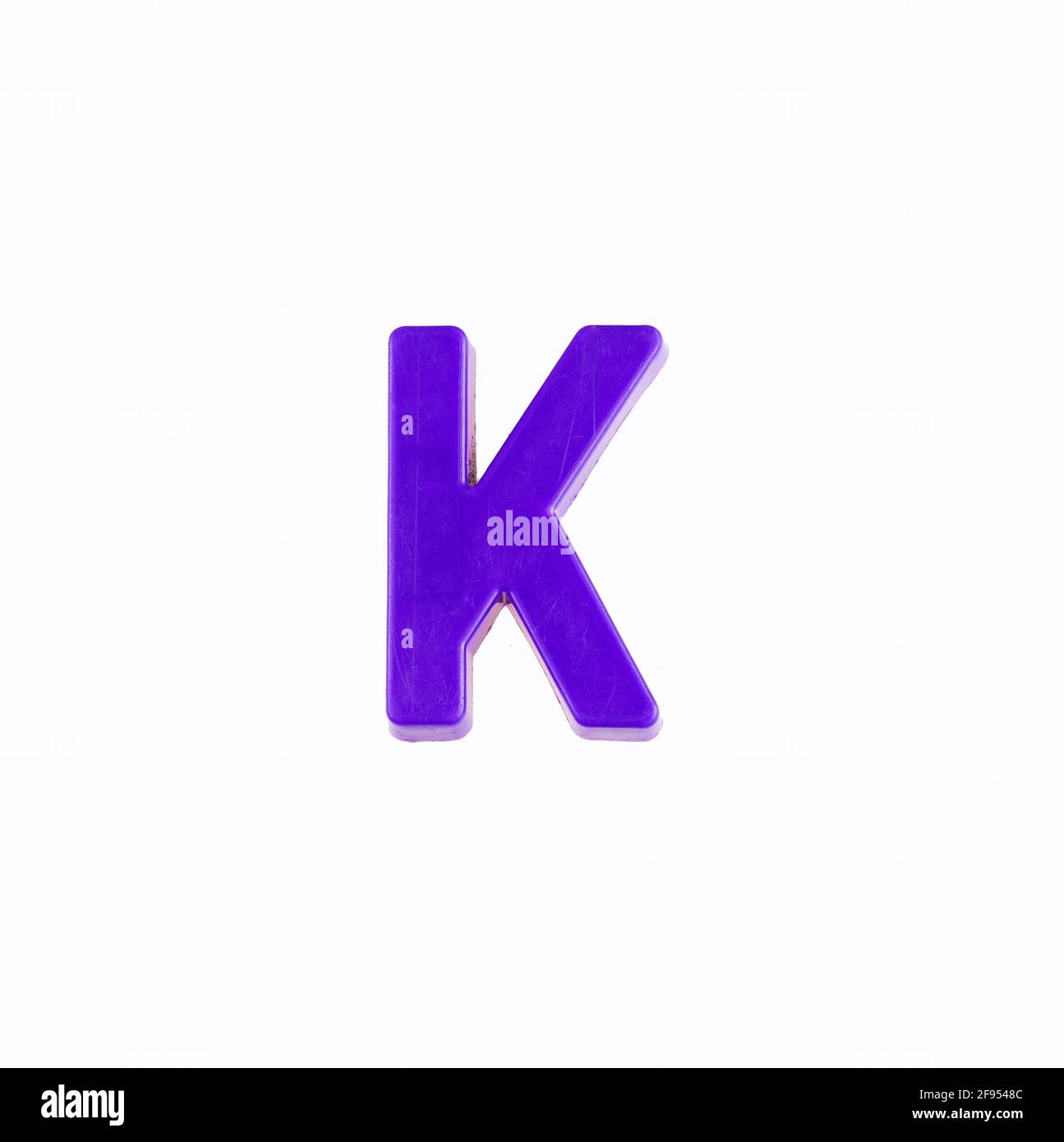 Letter K in violet color - Plastic piece Stock Photo - Alamy