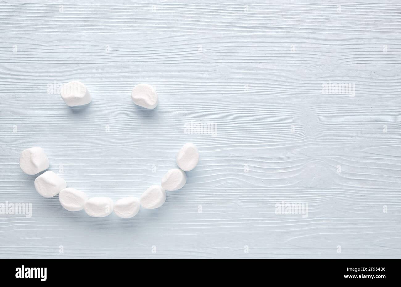 Smiley marshmallow on a light wooden background Stock Photo - Alamy