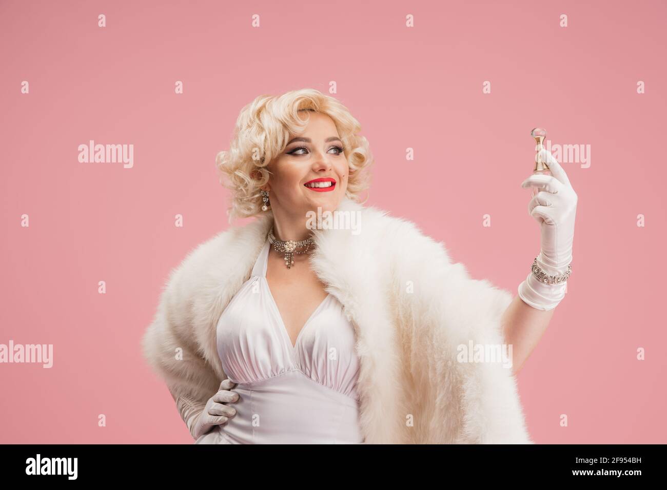 Portrait of young woman in white dress on coral pink background. Female ...