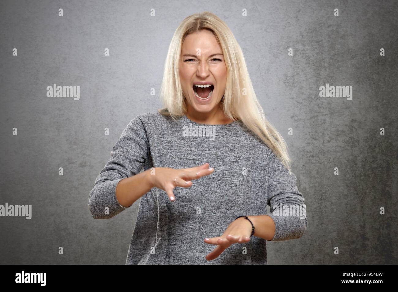 Angry woman screaming with rage. On a concrete gray background., Angry ...