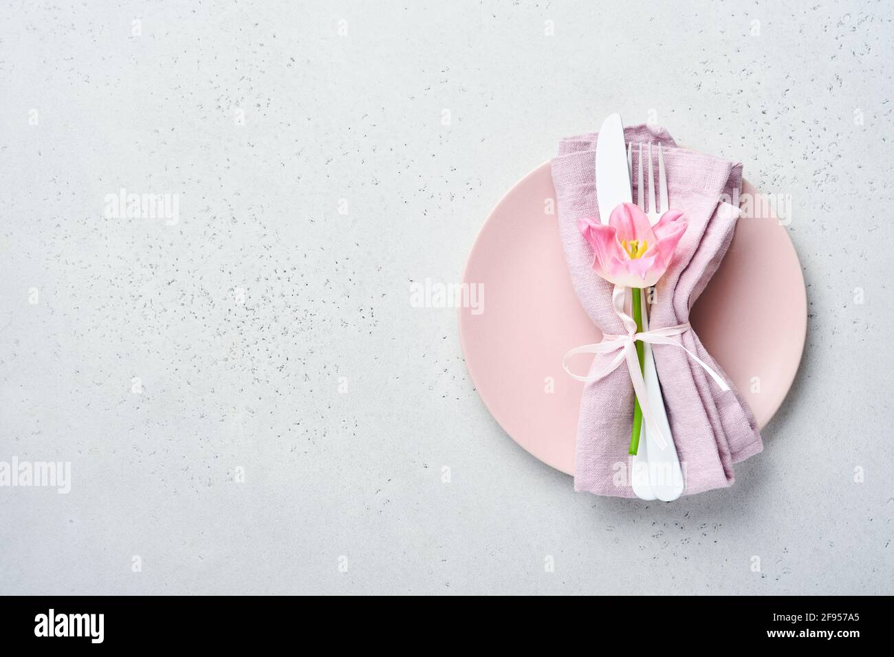 Table setting with floral decor on light grey table background. Easter ...
