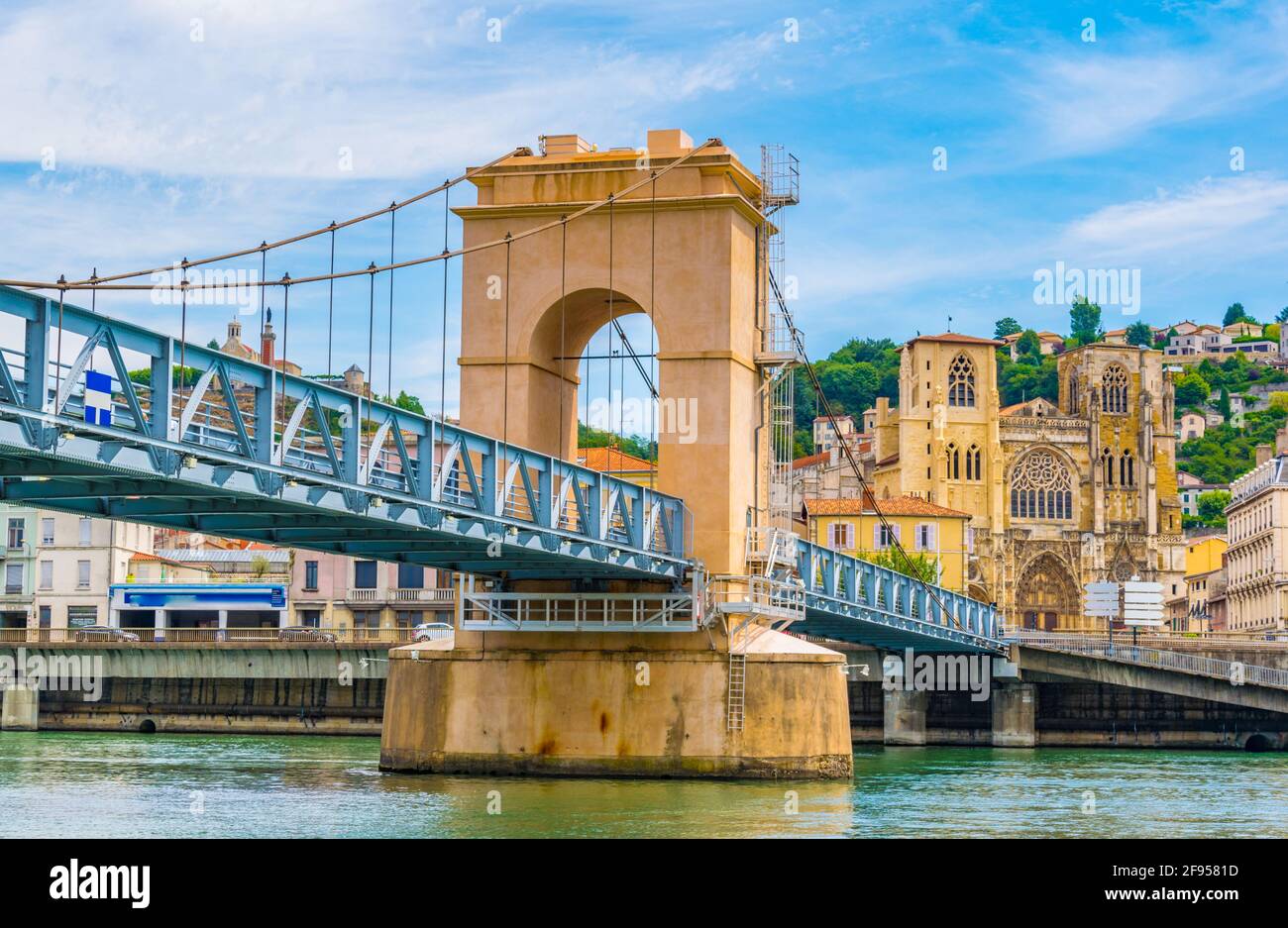 Cathedral in Vienne viewed behind a pedestrian bridge over river Rhone ...