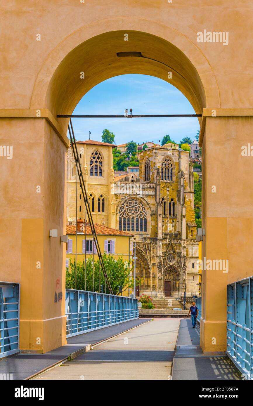 Cathedral in Vienne viewed behind a pedestrian bridge over river Rhone ...