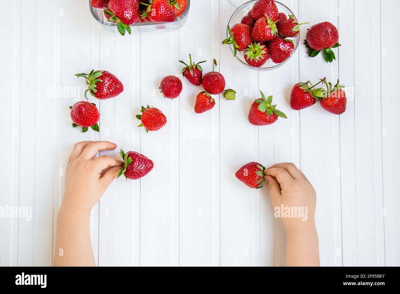 strawberry in the hand of a child on a white background Stock Photo - Alamy