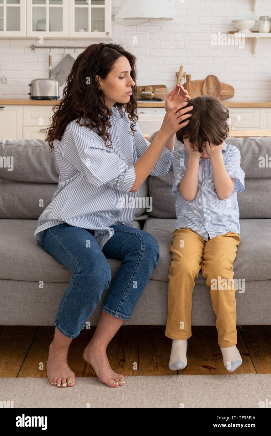 Portrait of worried mother with crying son. Disturbed young mom comforts and supports depressed ...