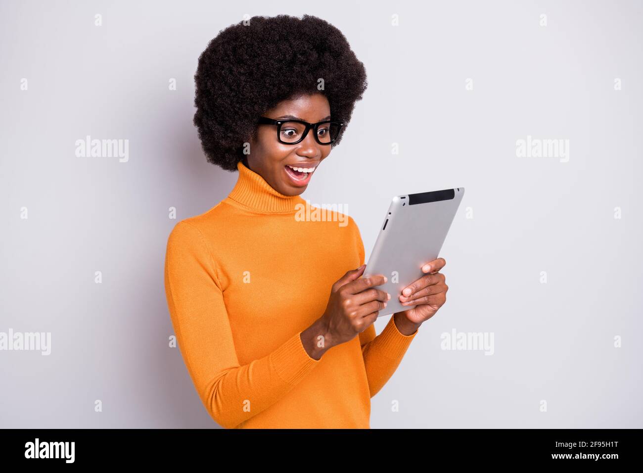 Photo portrait of amazed afro american woman holding tablet in two ...