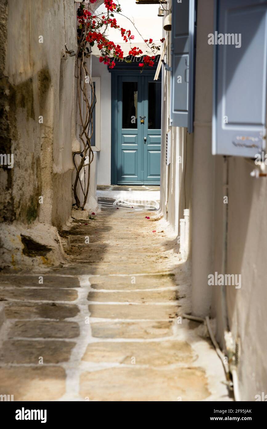 Narrow stone walkway leads to a painted door on the Greek Island of ...