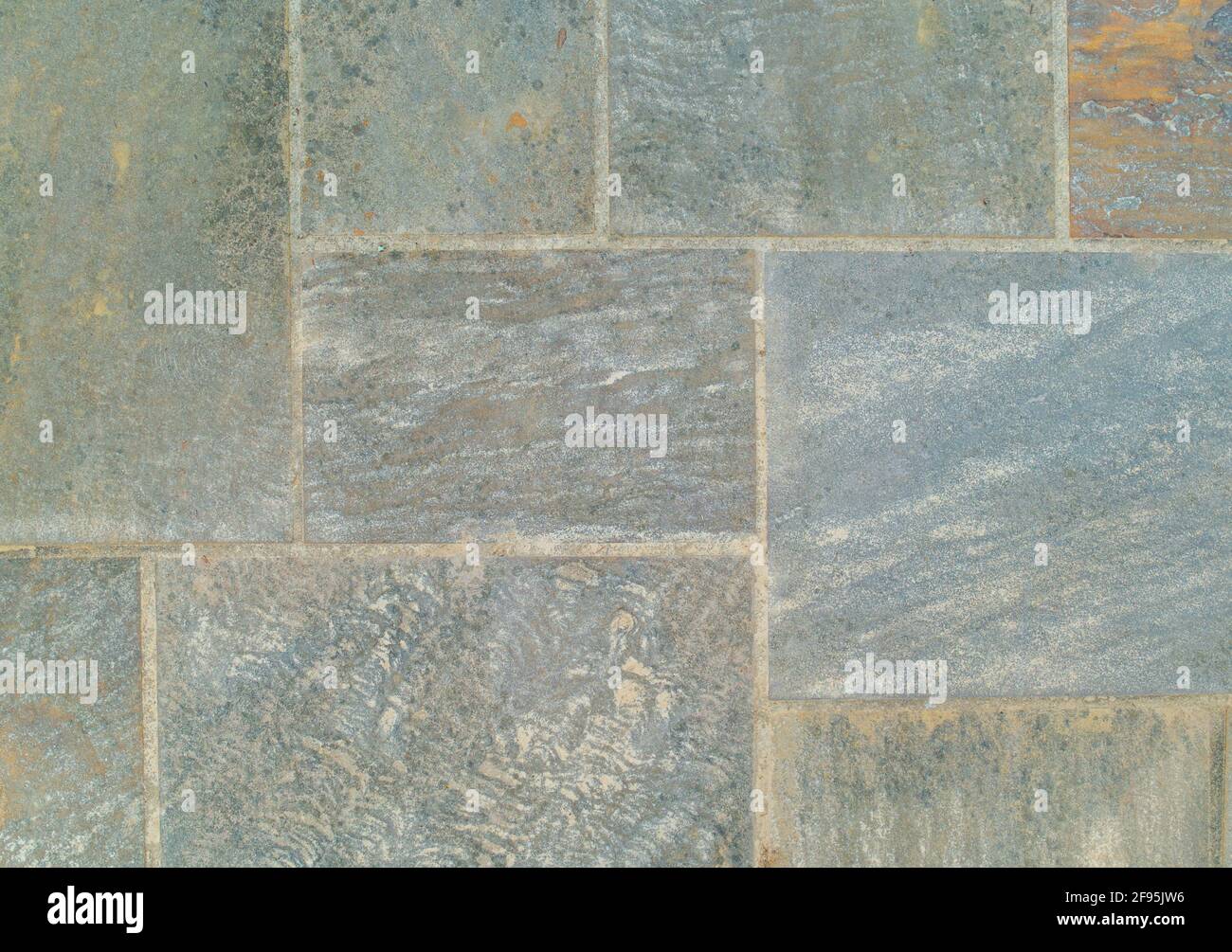 Looking down on old colorful cut rock and stone set in cement in ...