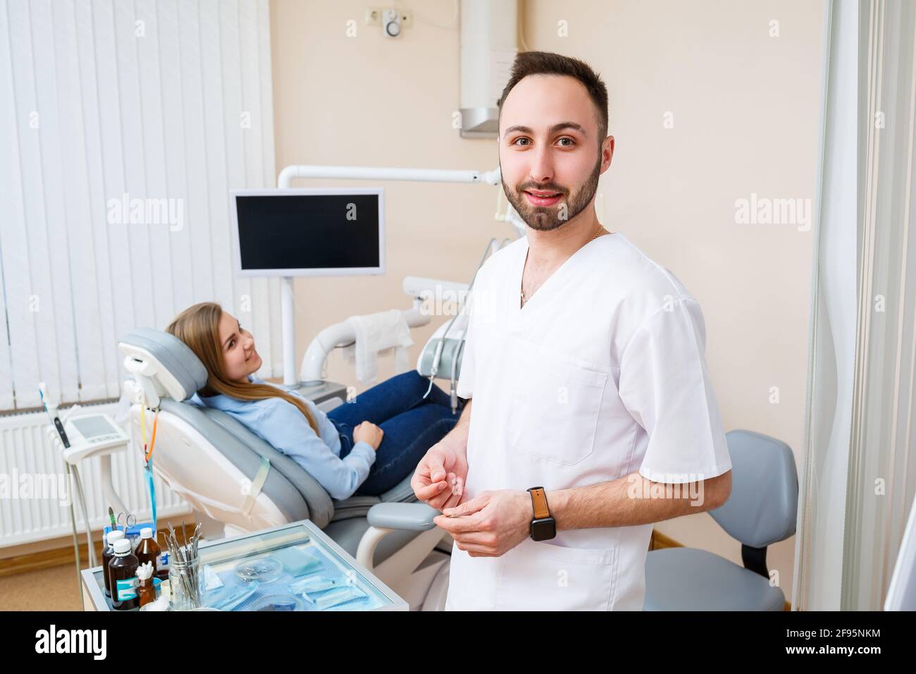 A professional dentist communicates with a woman patient. Dental office ...