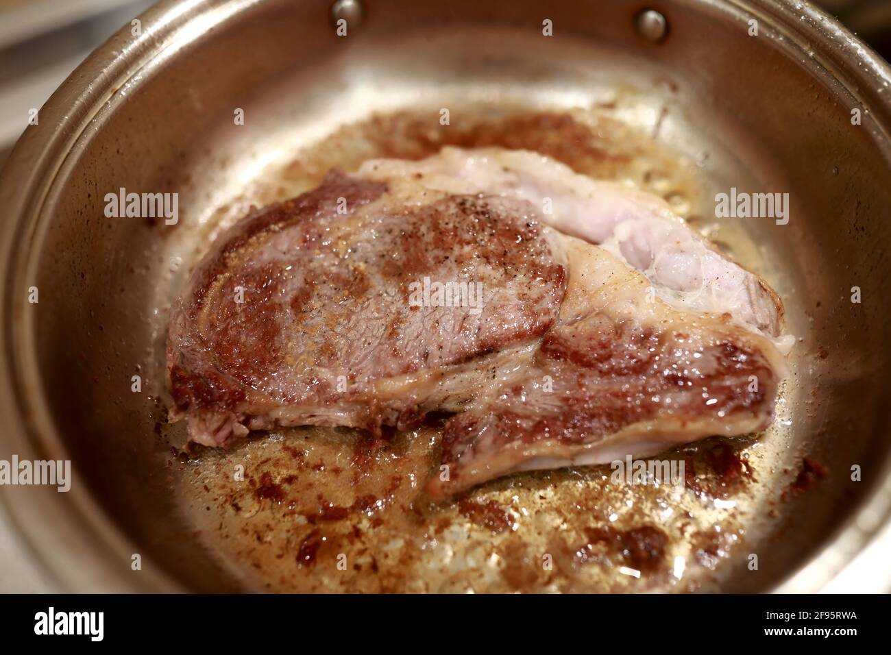 Frying beef steak in pan at home Stock Photo - Alamy