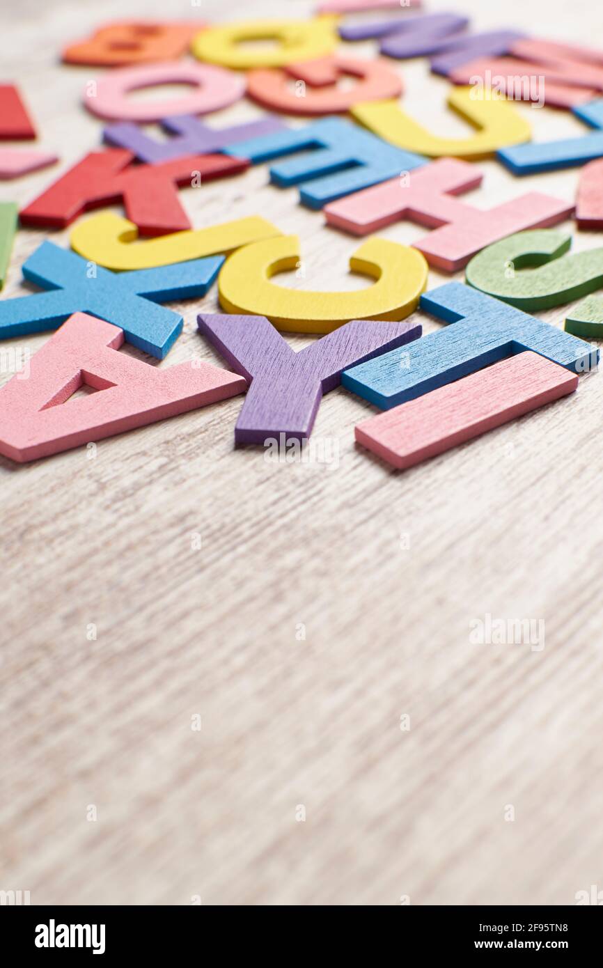 Colors alphabet letters in a clear wood background Stock Photo - Alamy