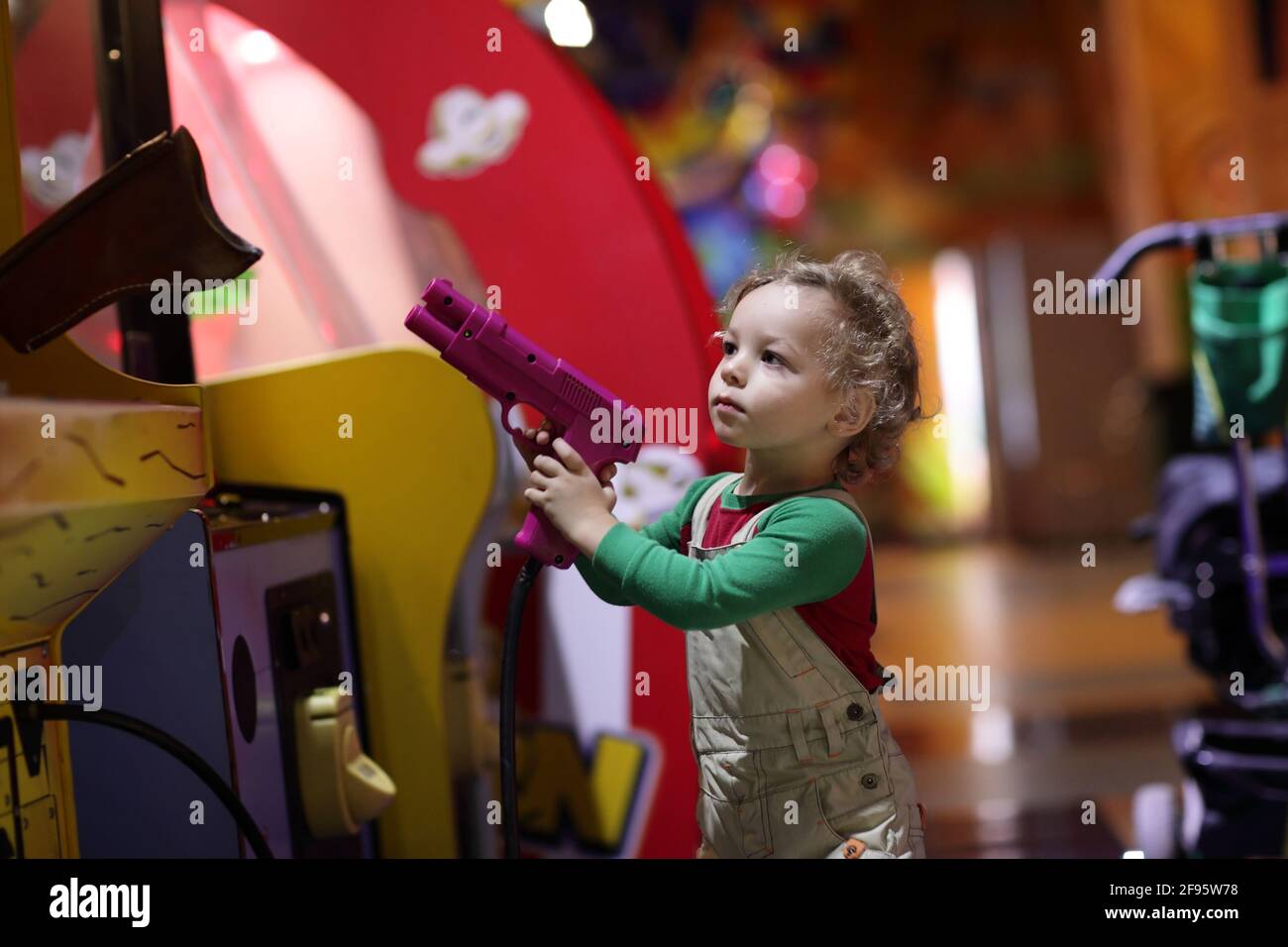 Boy aiming a gun at indoor playground Stock Photo - Alamy