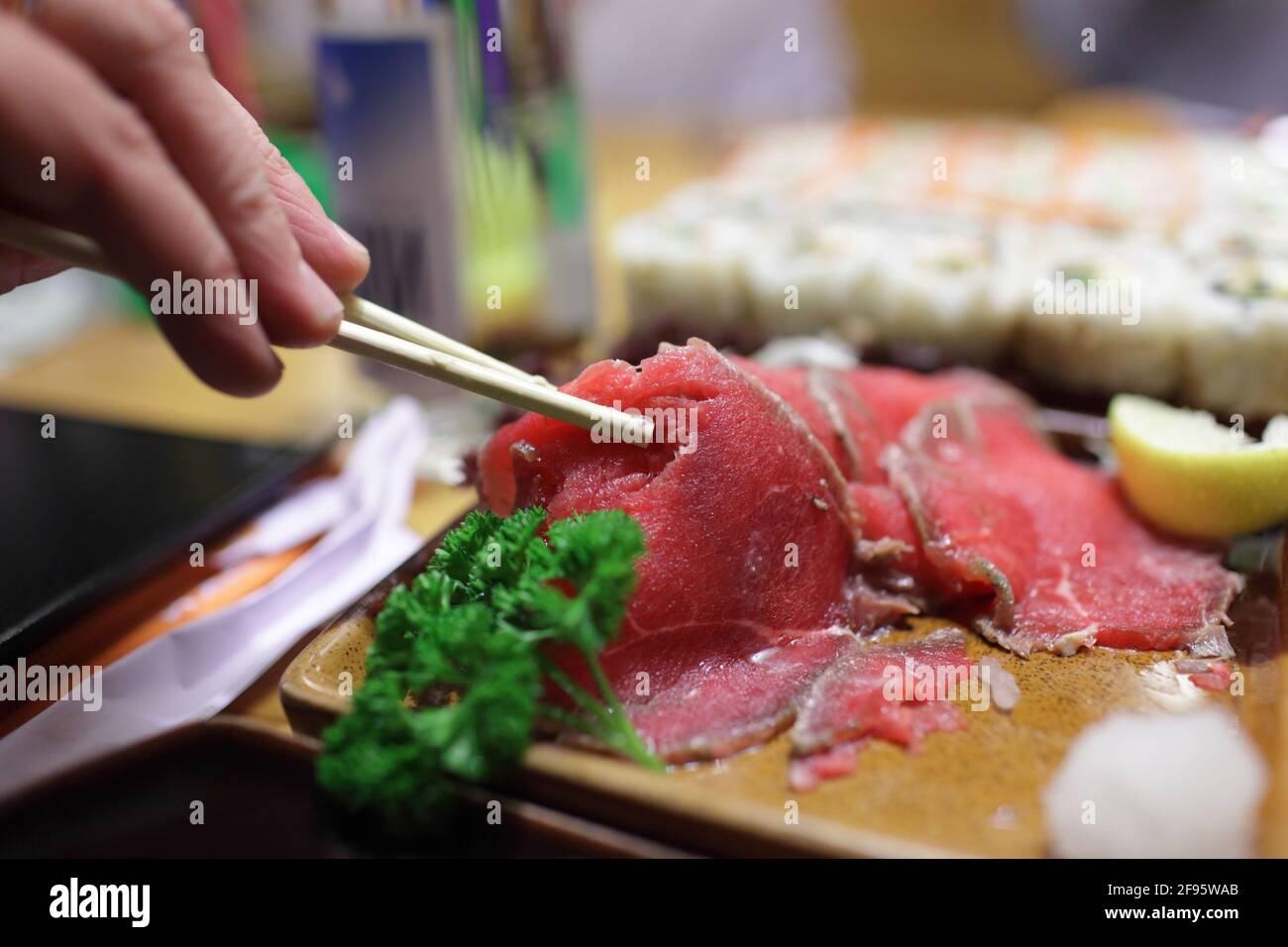 Person takes gyuniku tataki in the japanese restaurant Stock Photo - Alamy