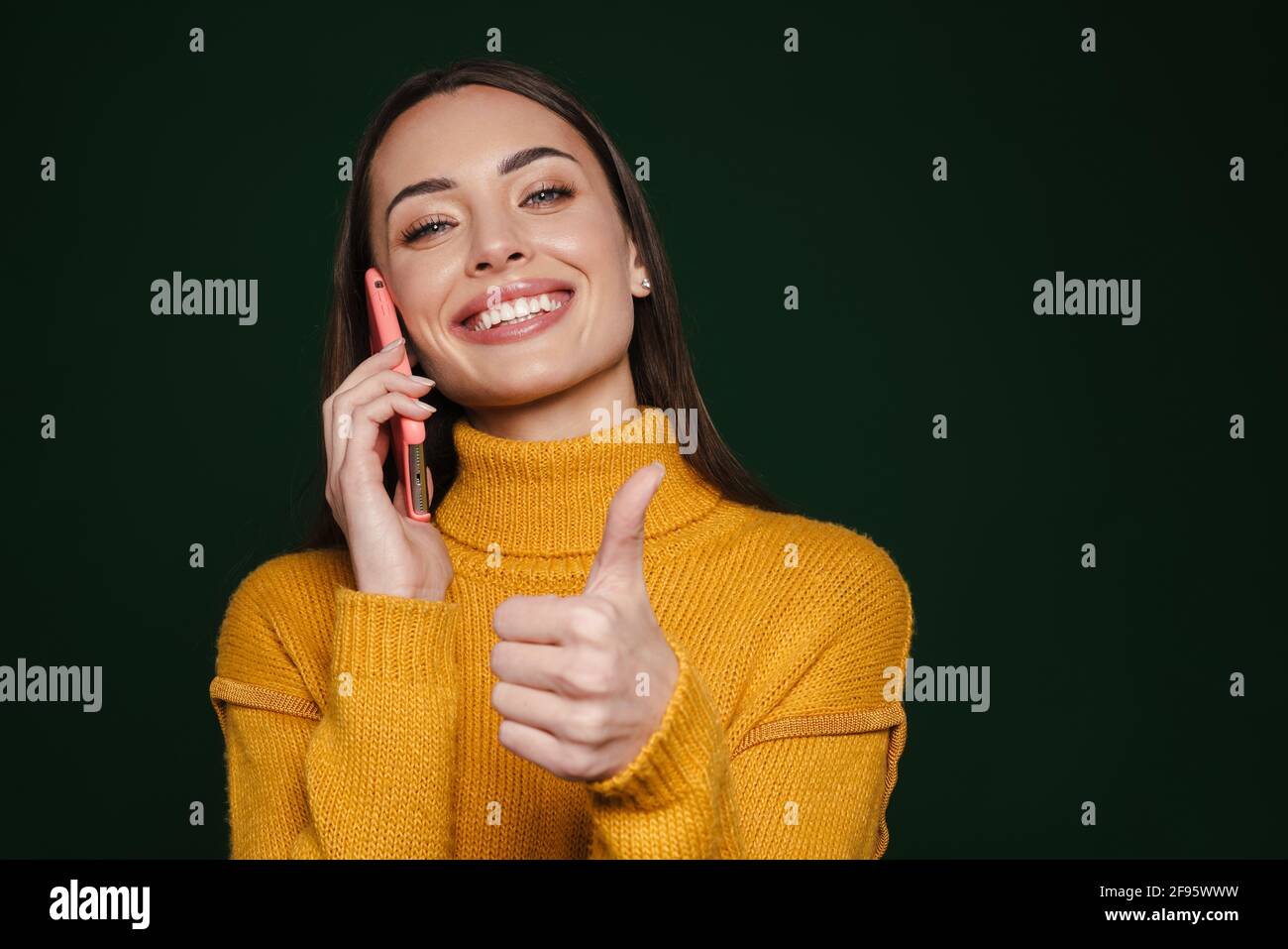 Happy beautiful girl showing thumb up and talking on mobile phone ...