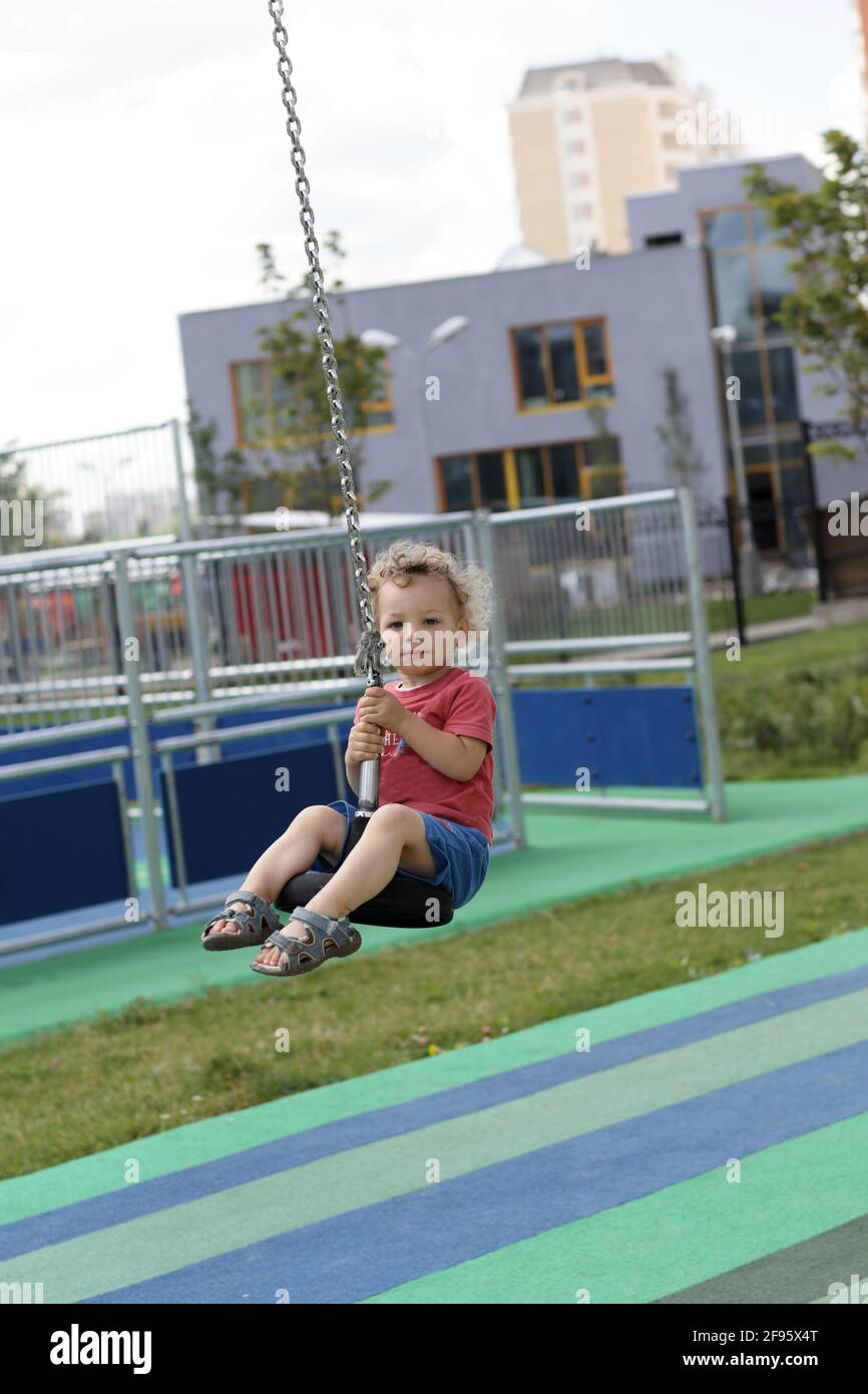 Curly boy is playing at cableway at playground Stock Photo - Alamy