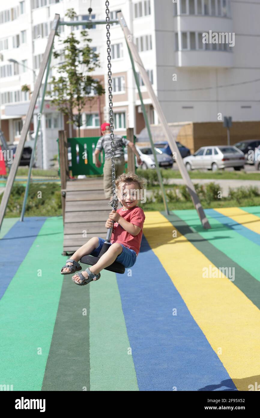 Curly toddler is playing at cableway at playground Stock Photo - Alamy