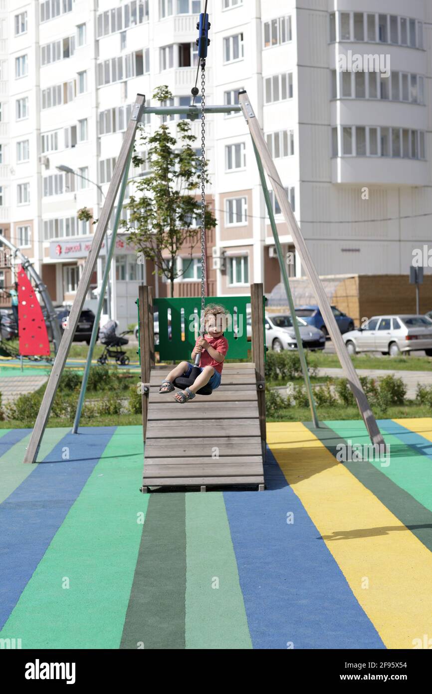 Curly child is playing at cableway at playground Stock Photo - Alamy