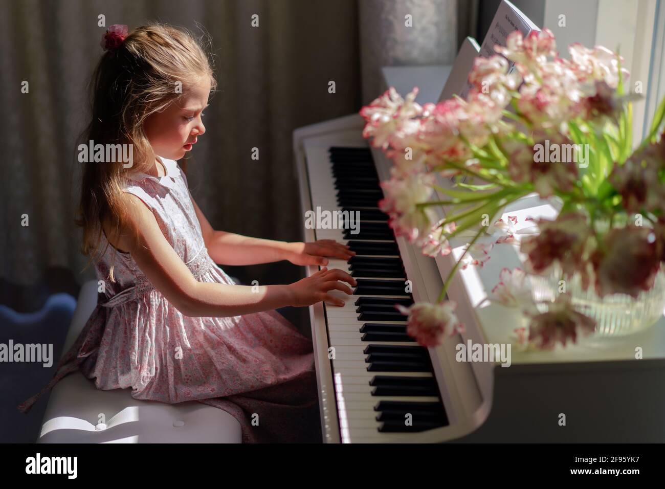 Young girl practicing piano at home. Beautiful scene. Indoor activity ...
