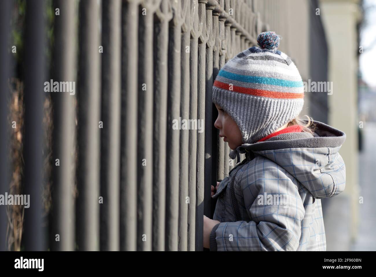 The child looking through the iron grating Stock Photo - Alamy