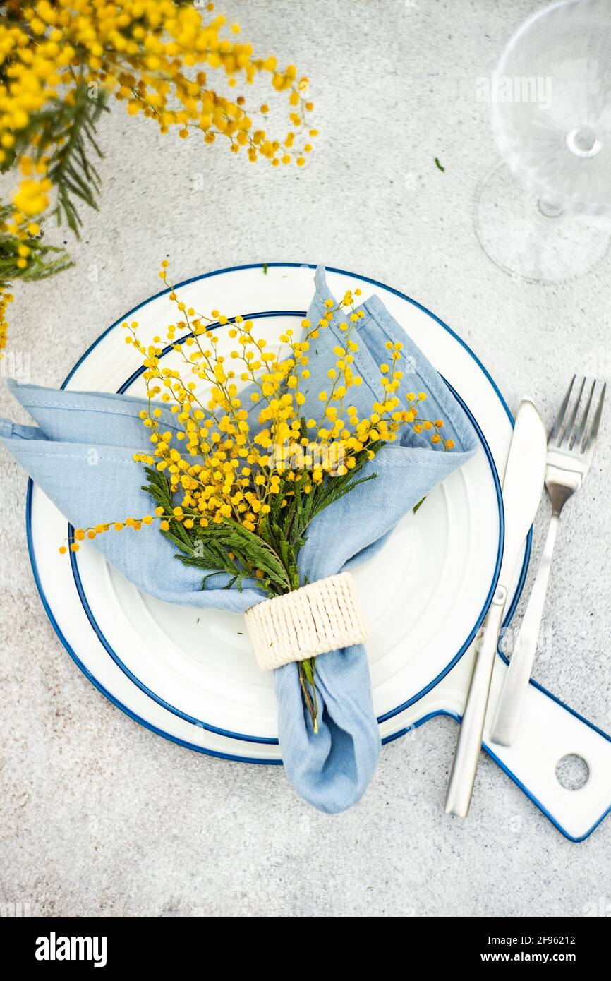 Spring mimosa flowers and table setting Stock Photo - Alamy