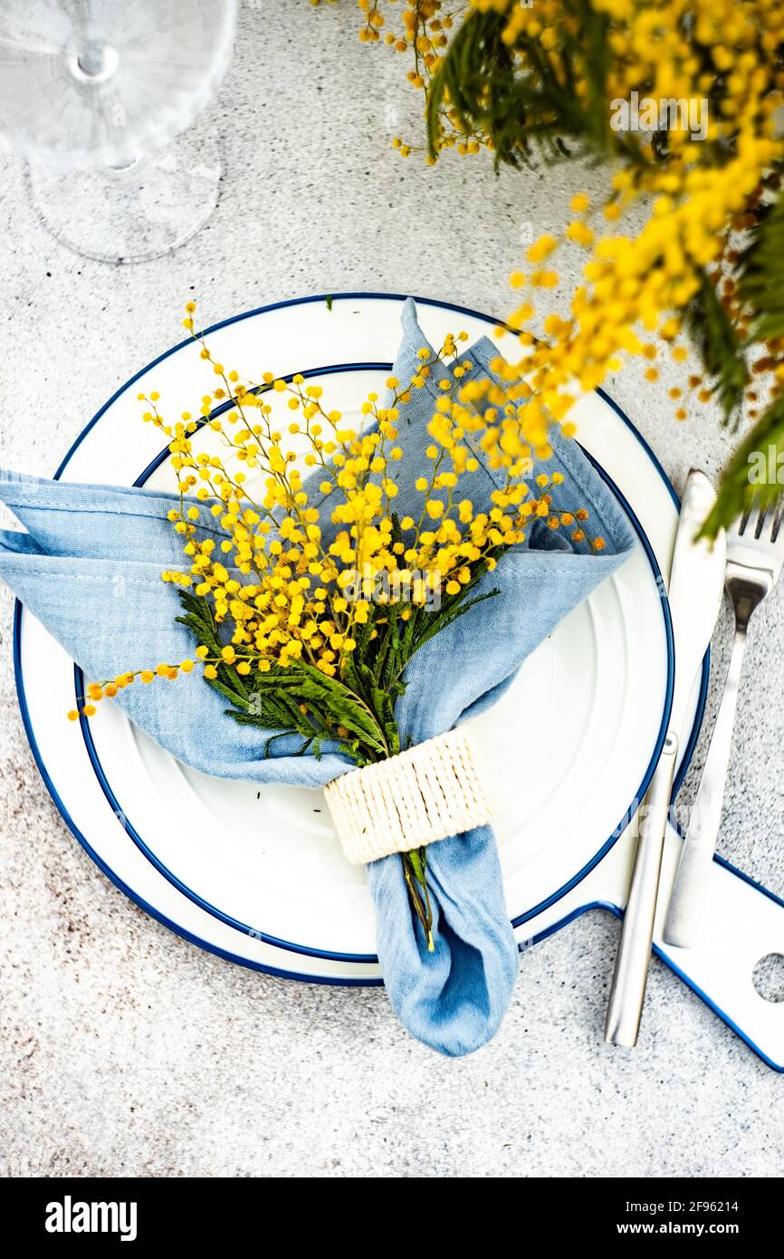 Spring mimosa flowers and table setting Stock Photo - Alamy