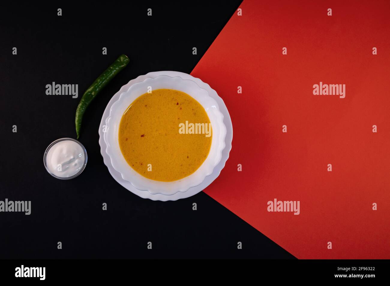 Overhead Shot Of Healthy Hot Soup Over A Black And Red Background Stock
