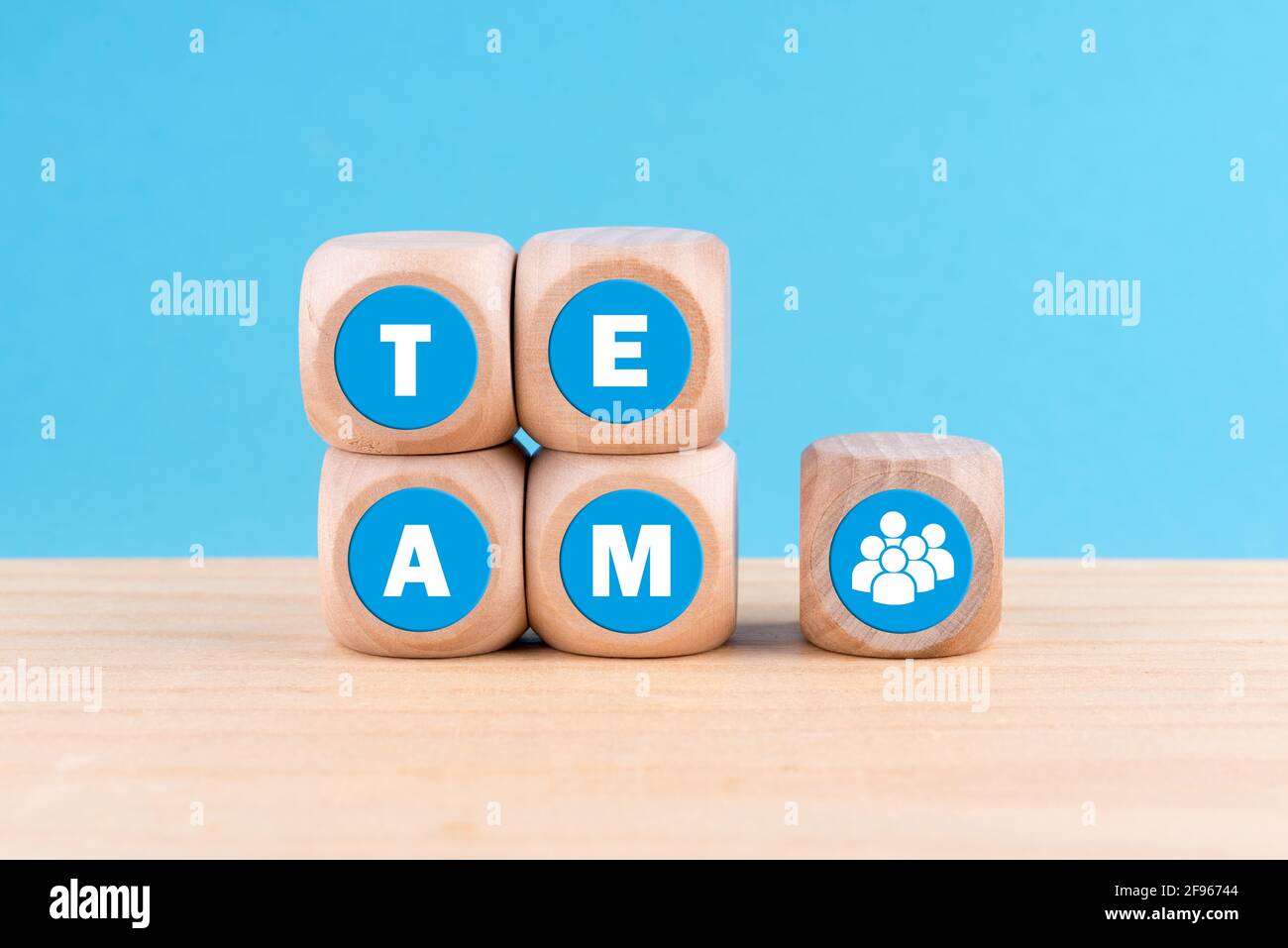 Word TEAM formed with wooden blocks and people icon in the blue ...