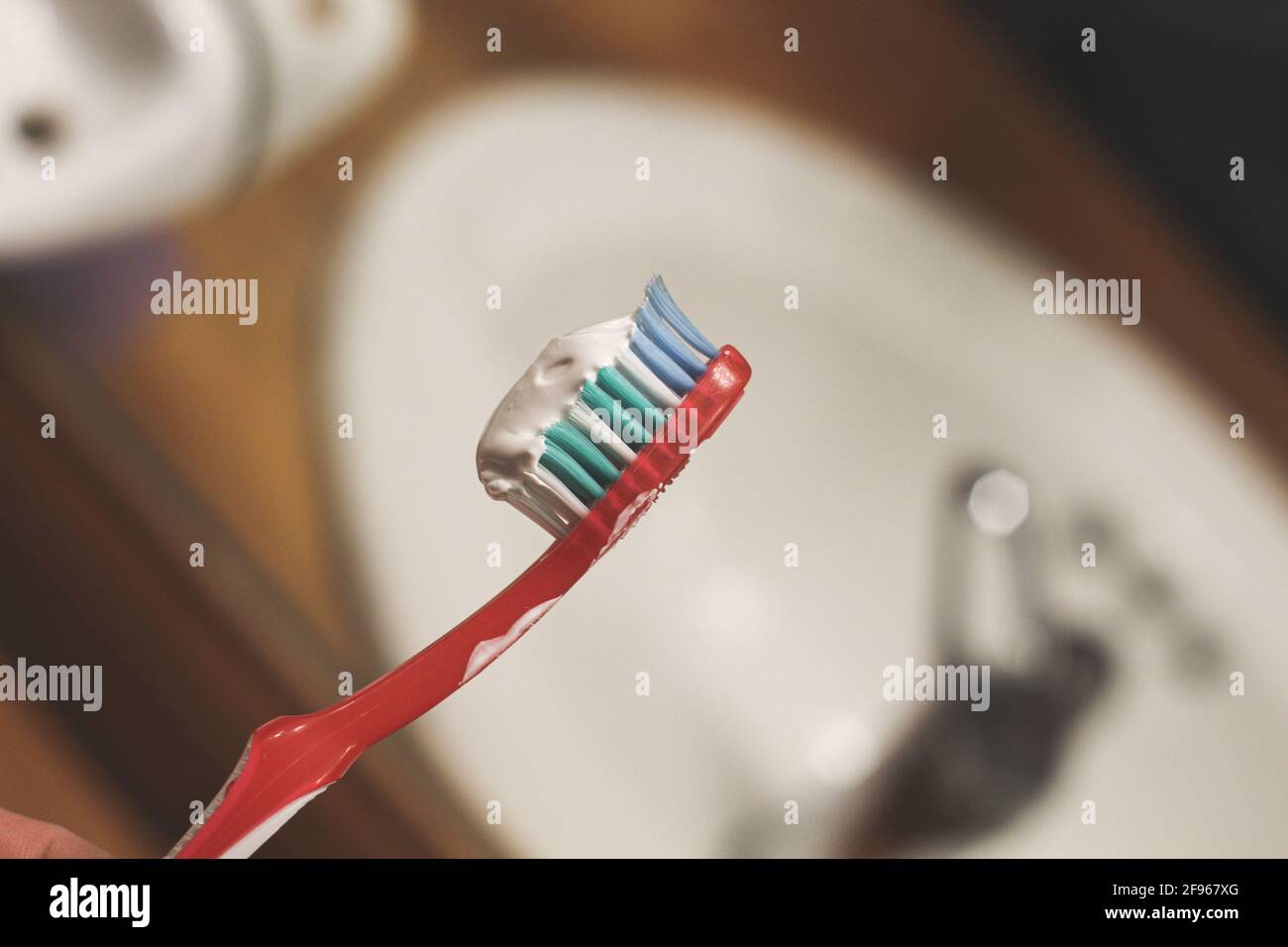 Red toothbrush with toothpaste on the surface is ready for use Stock ...