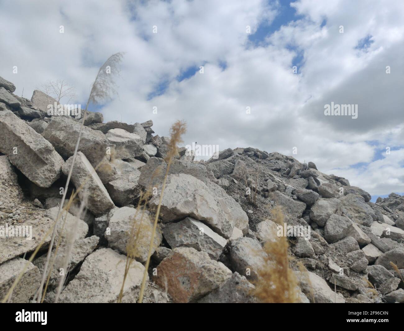 Low angle shot of a bunch of crushed stones in the field under a cloudy ...