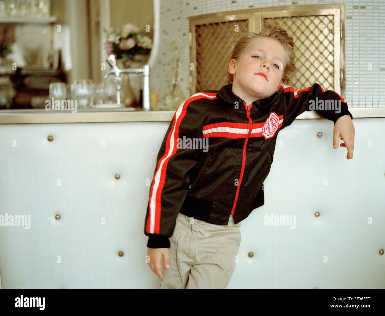 Boy stands leaning against the counter Stock Photo - Alamy