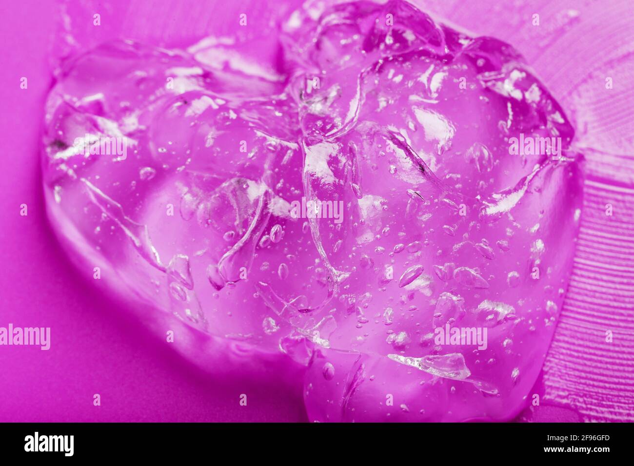 Transparent liquid gel on a pink background with free space. Antiseptic ...