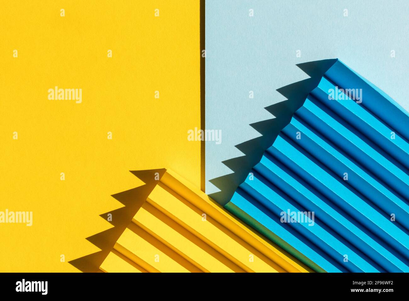 Abstract blue and yellow colored paper texture. Folded paper with harsh ...
